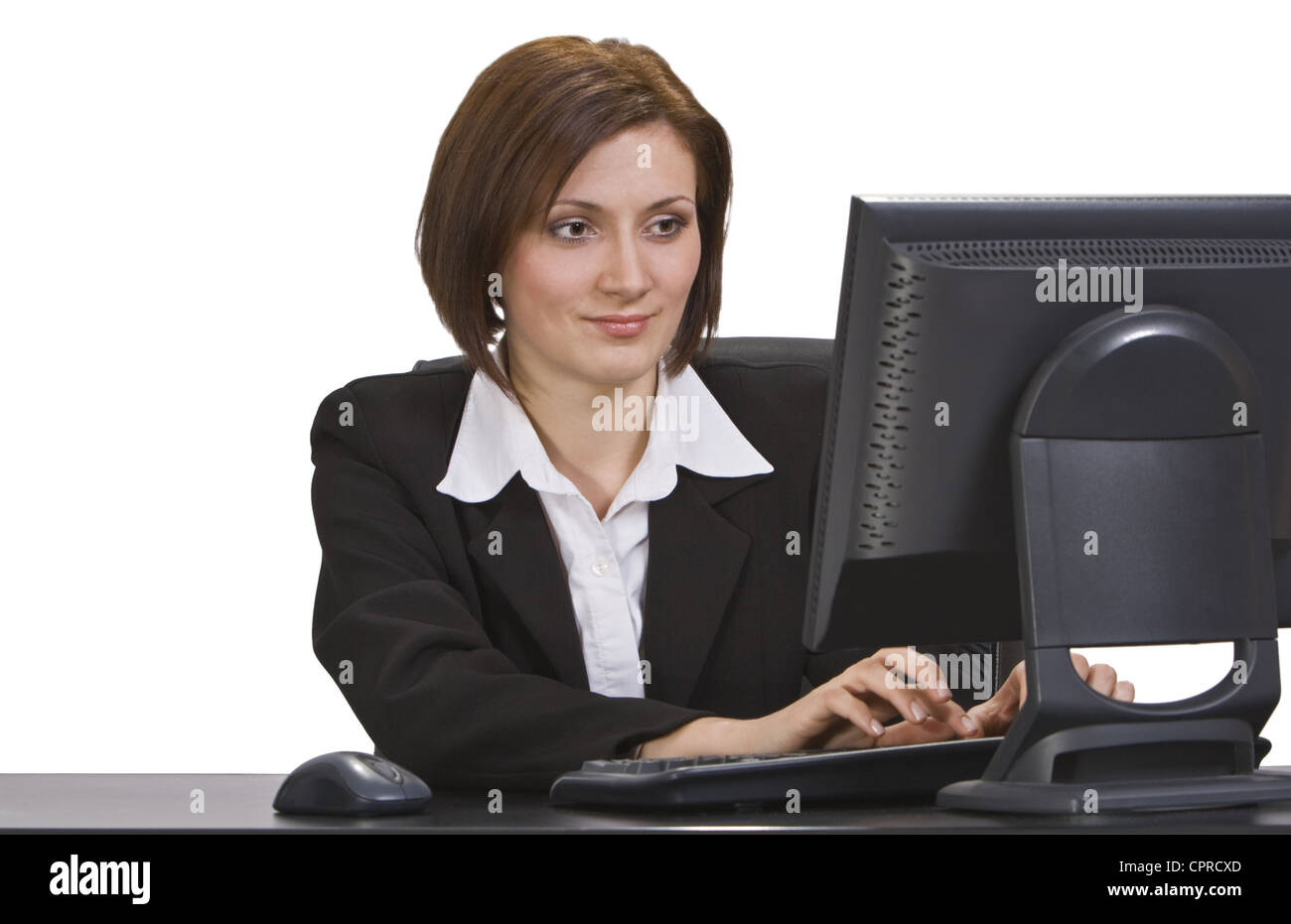 Businesswoman working on a computer at her office desk isolated against ...