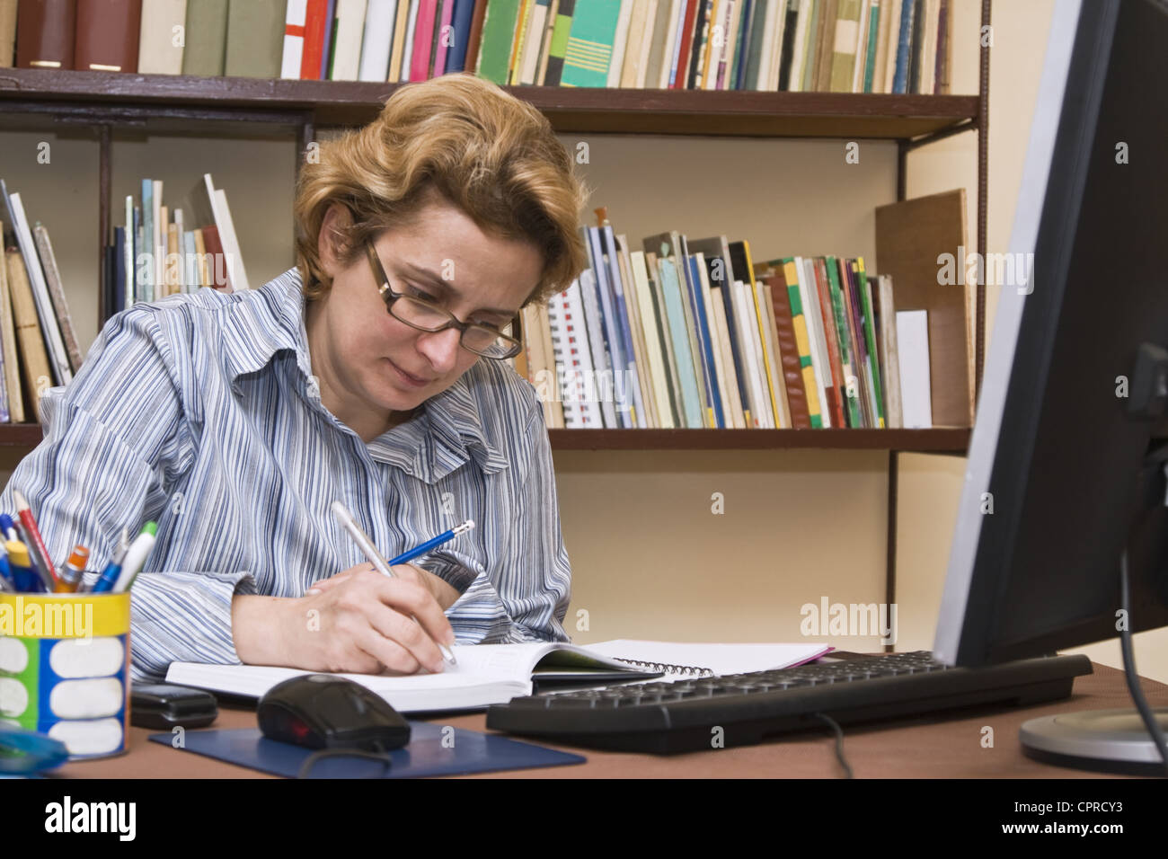 Woman writing something at her home business desk Stock Photo - Alamy