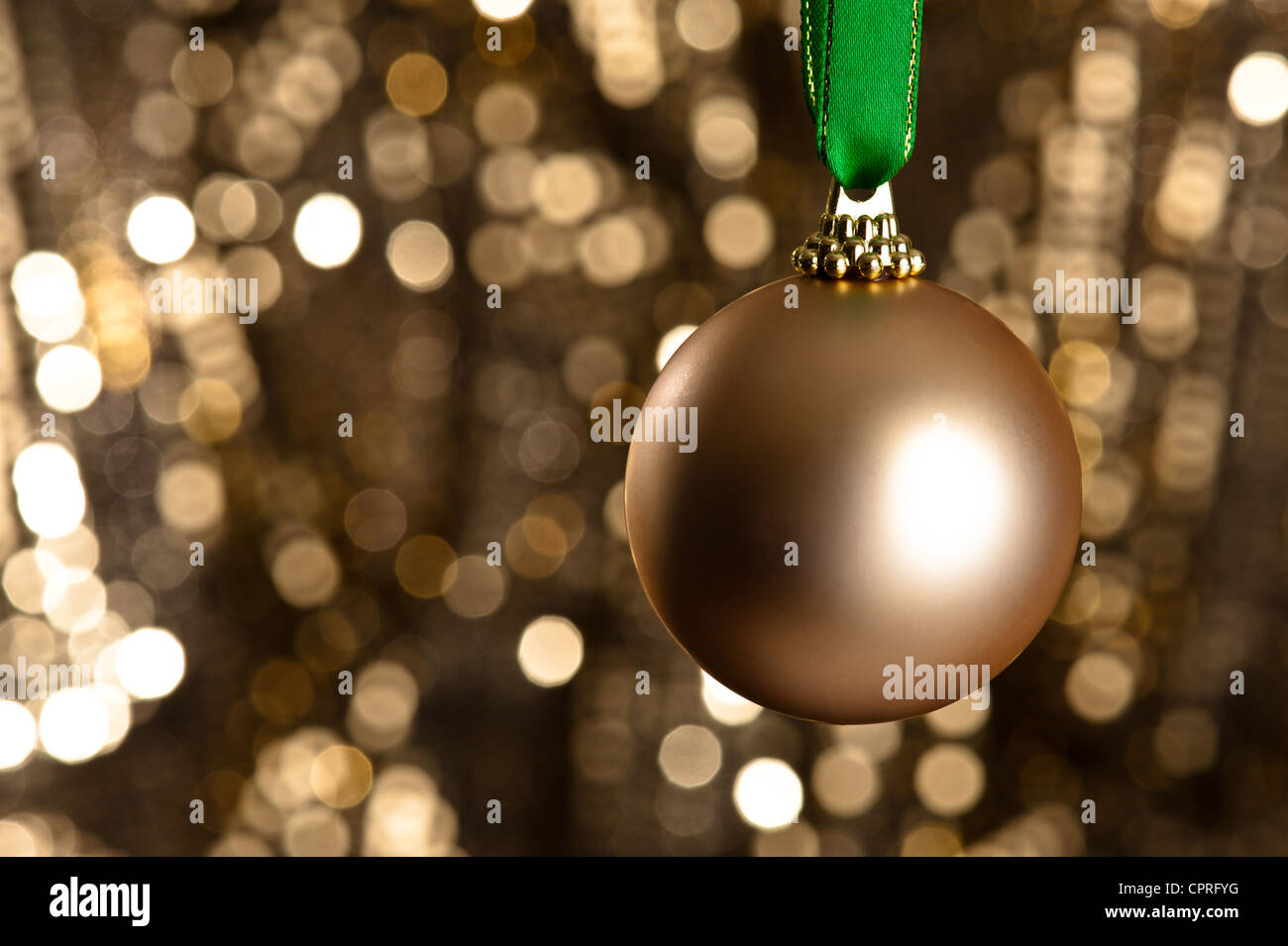 Single gold Christmas bauble in front of a gold glitter background for ...