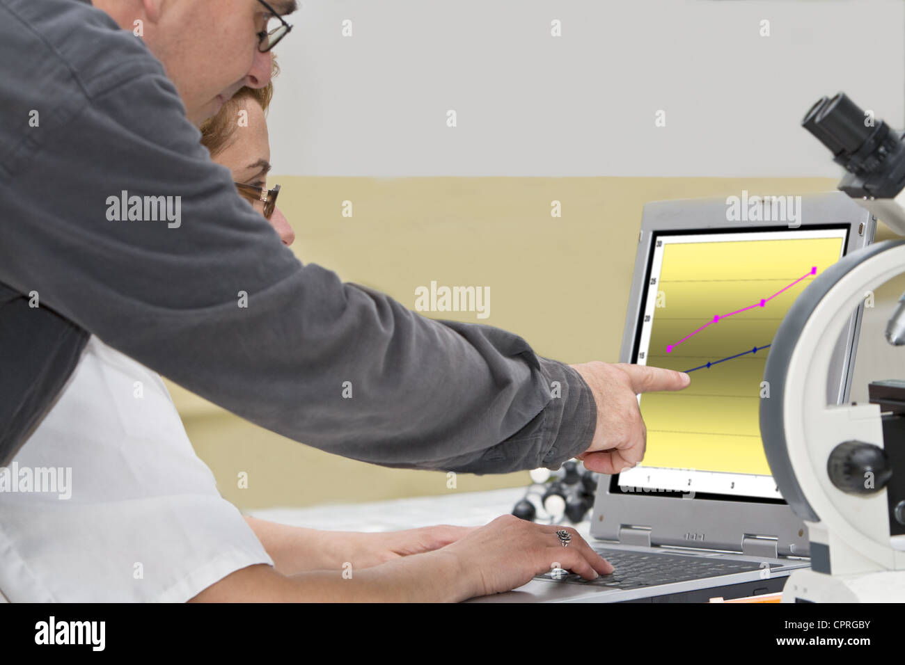 Two researcher colleagues analyzing the graph of the experiment results ...