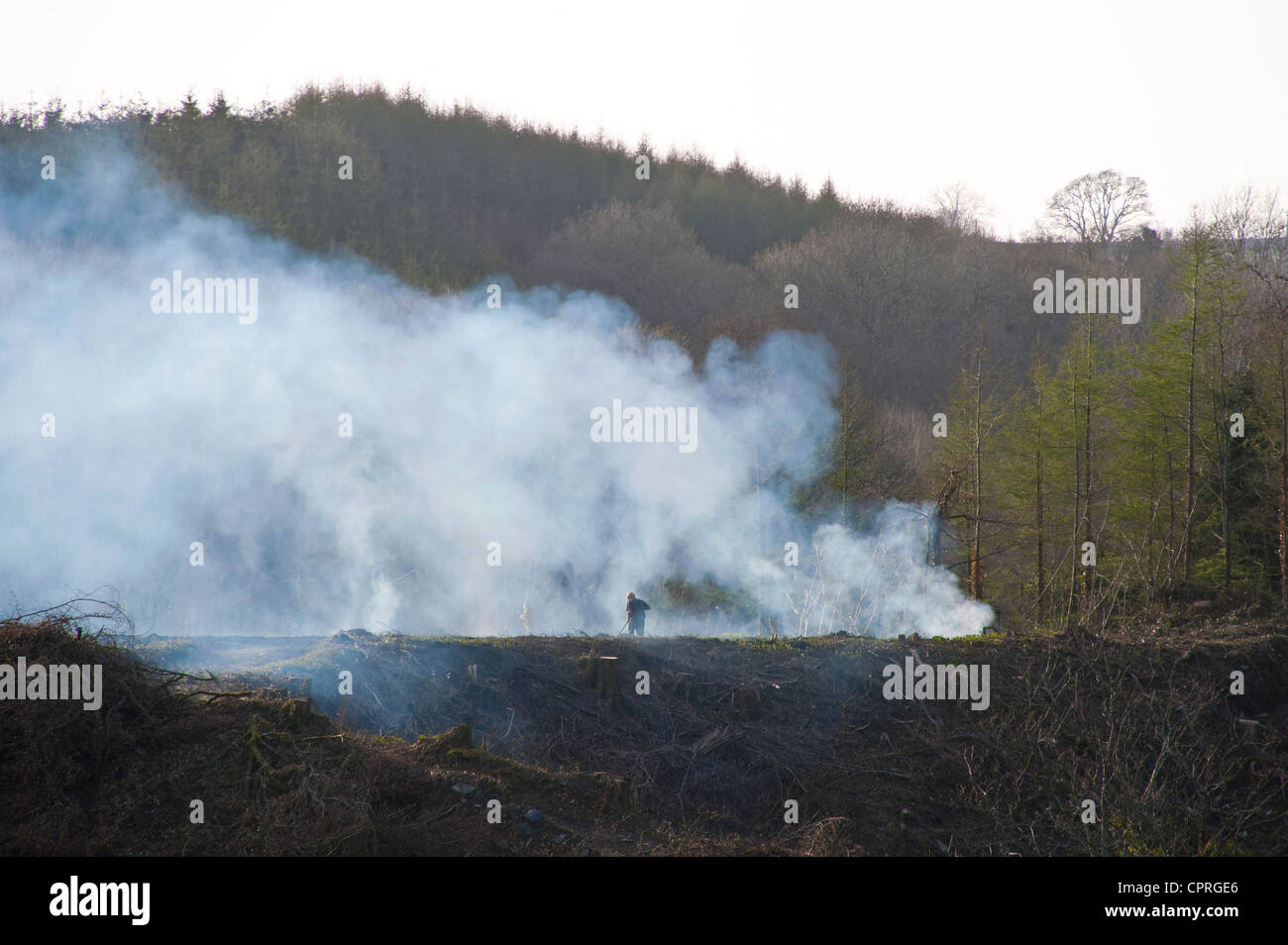 A man is just visible against the smoke from fires of burning scrub and ...