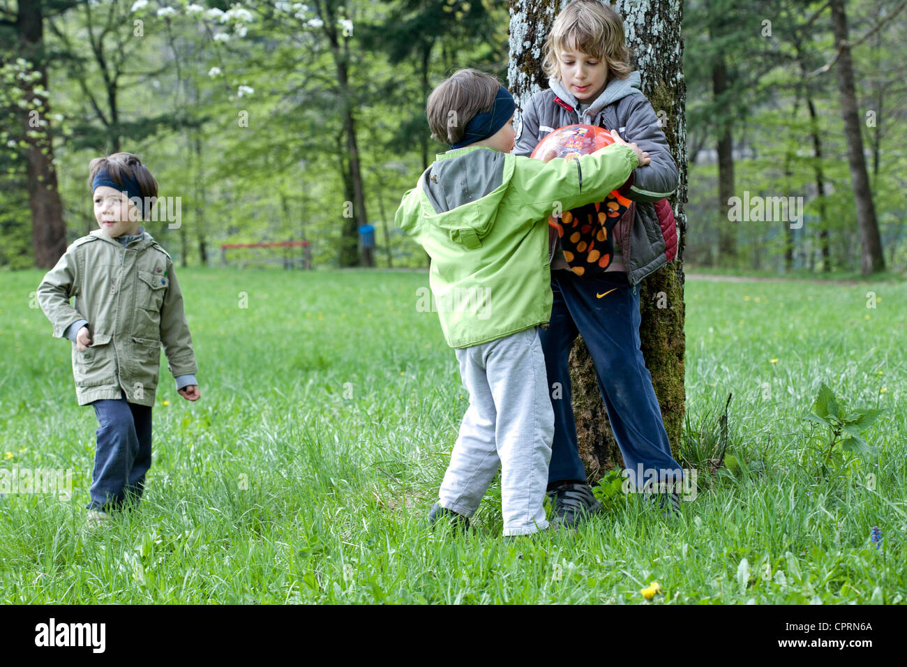 Boys playing outdoor. Older boy took the ball to the younger one ...