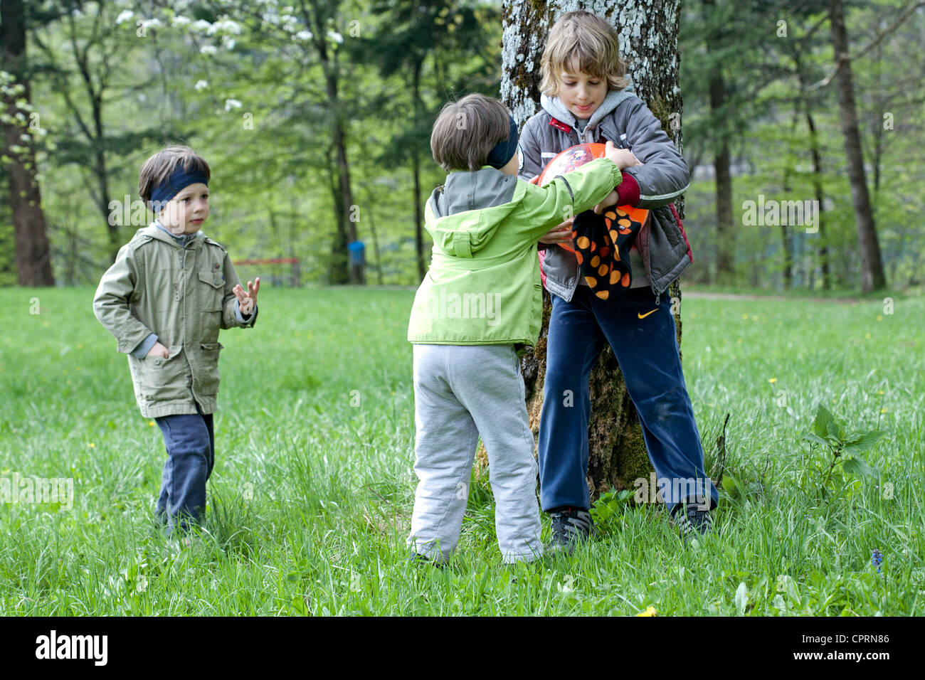 Boys playing outdoor. Older boy took the ball to the younger one ...