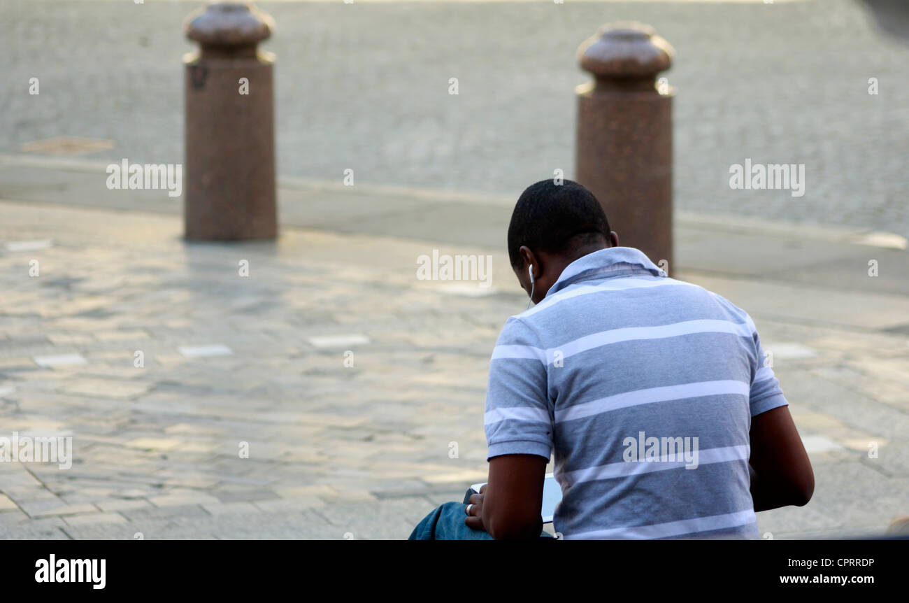 Lonely teenager listening to songs on the steps of St Pauls Cathedral ...