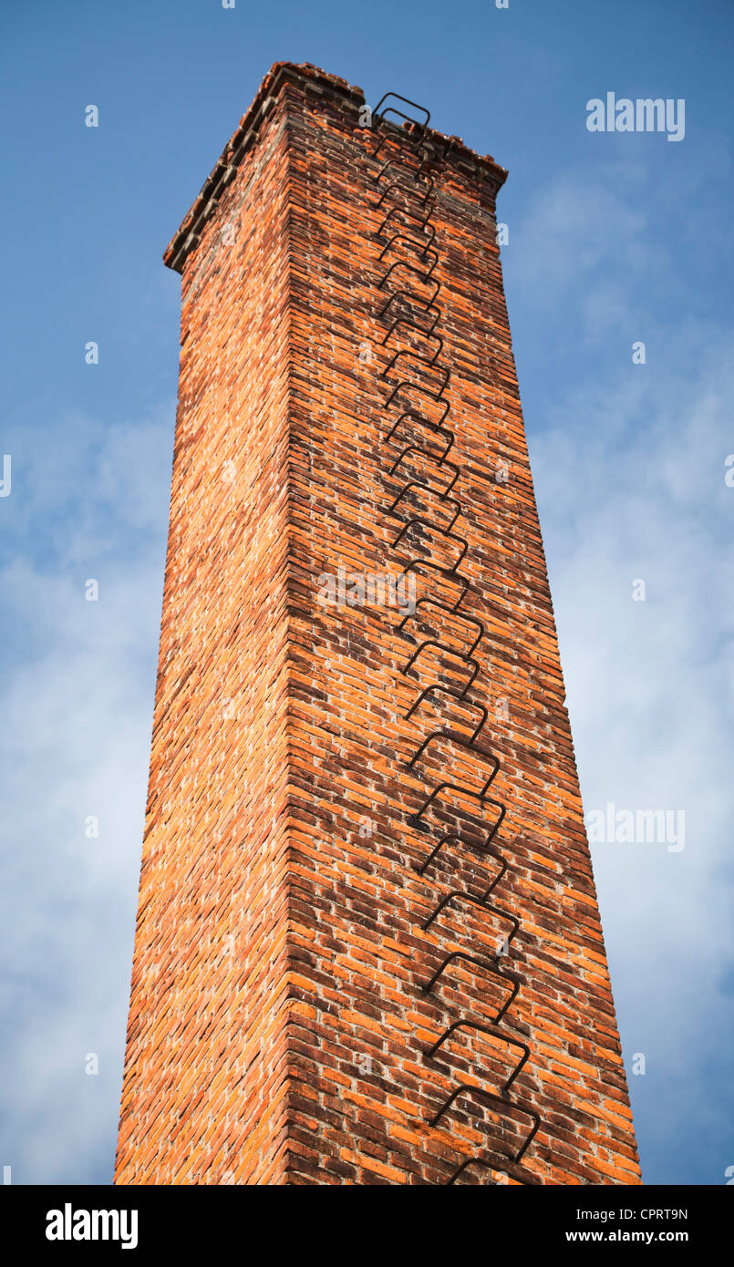 Red brick tube on bright cloudy sky background Stock Photo - Alamy