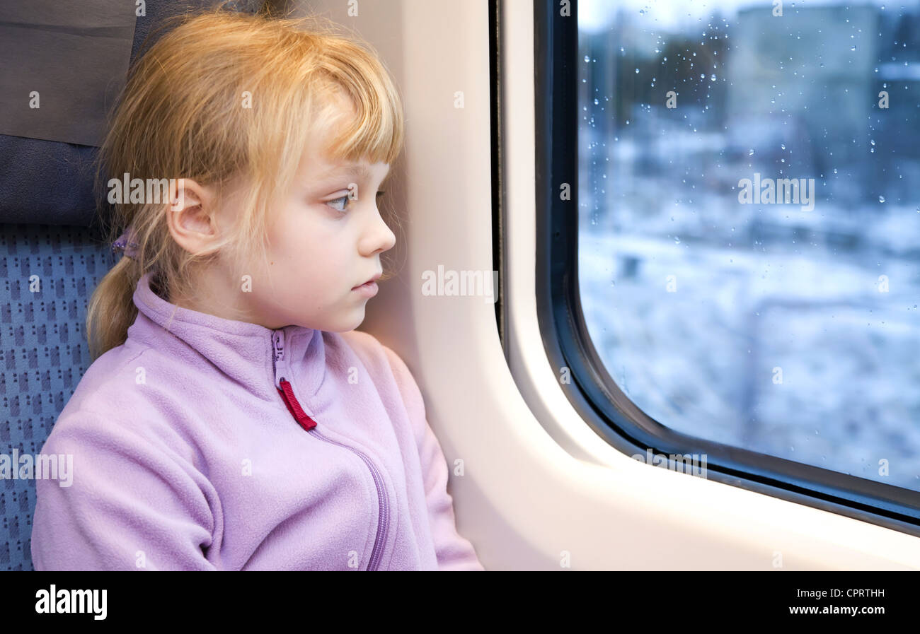 Little girl as a passenger of high speed train are looking in the ...
