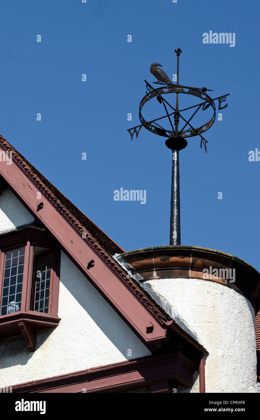 Large ornate metal weather vane on a tudor-styled building in the ...