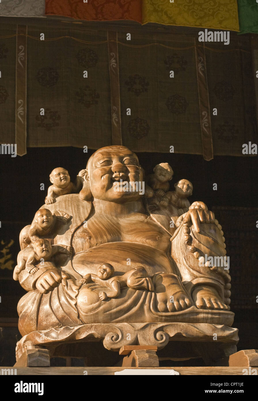 A wooden statue of Buddha and many children symbolizing fertility Stock ...