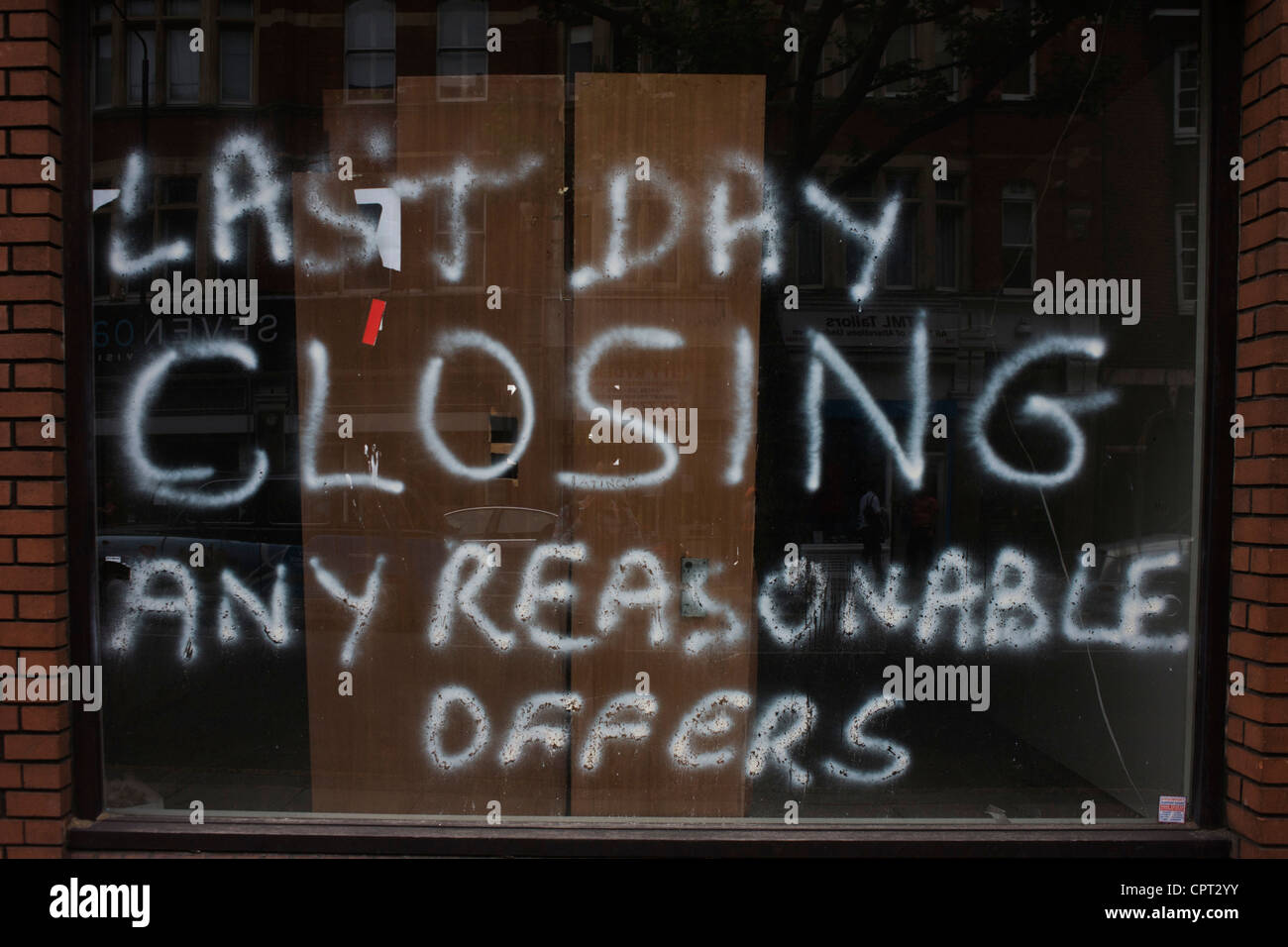 Sprayed writing on a closed recession business window Stock Photo - Alamy