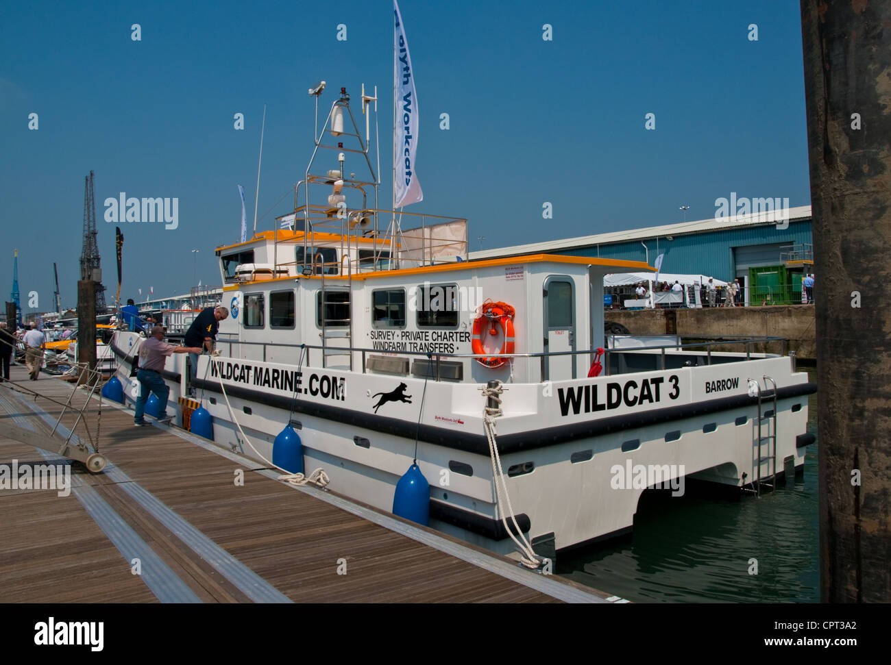 A catamaran workboat, port side, along side a jetty Stock Photo - Alamy