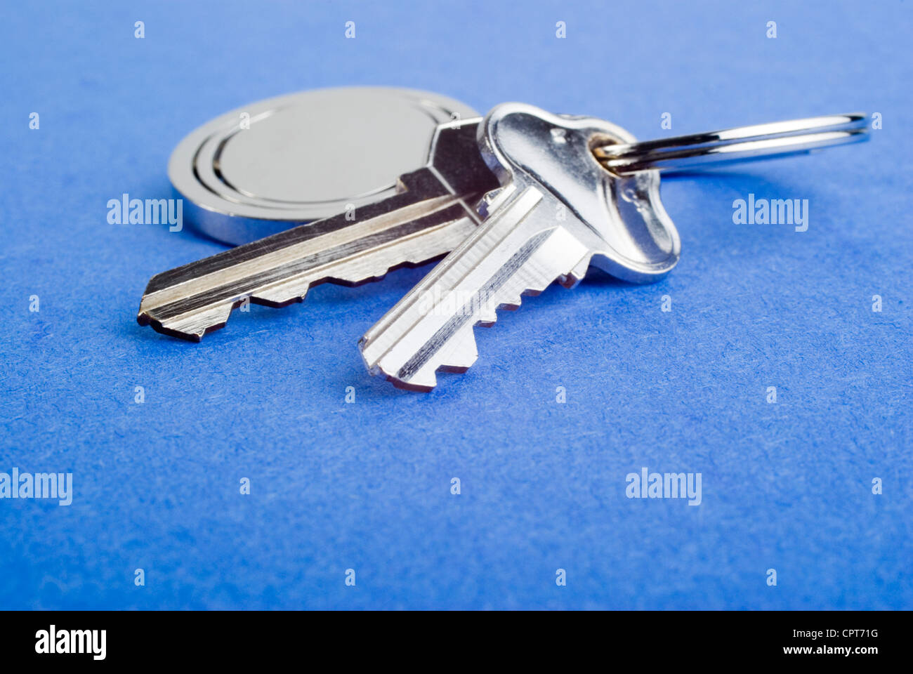 Set of silver coloured house keys on blue texture background Stock ...