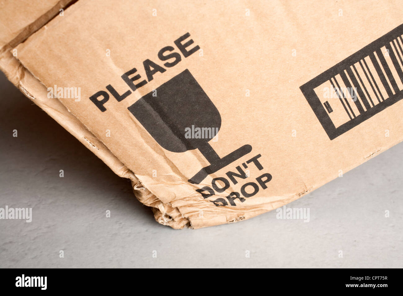 Cardboard box with 'Please Don't Drop' notice dropped on hard tiled ...