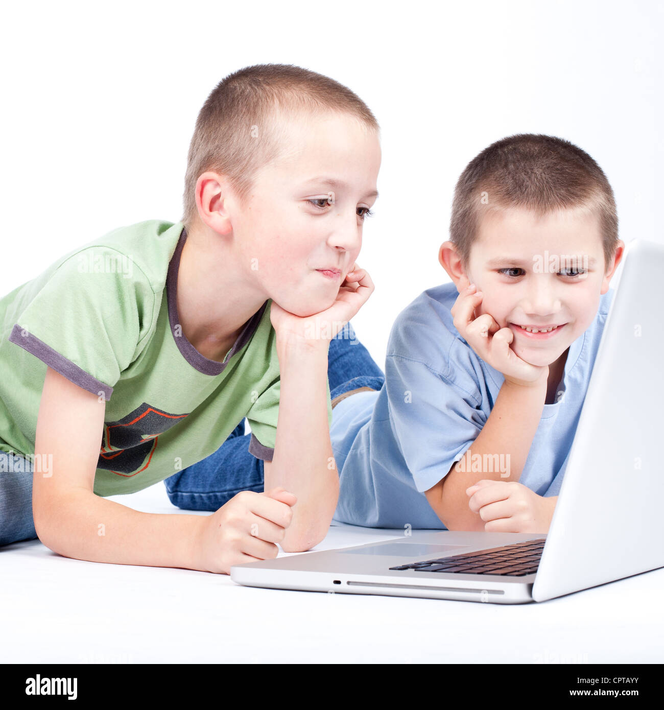 Boy using a modern laptop computer while lying on the floor (isolated ...