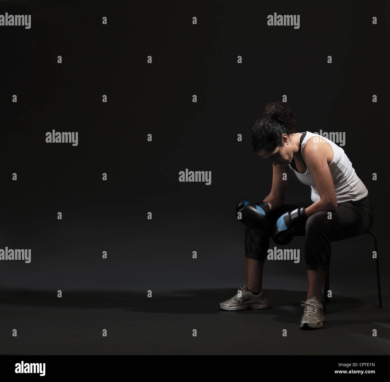 Female boxer sitting against black background Stock Photo - Alamy