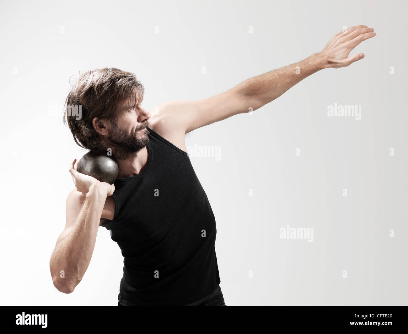 Athlete performing shot put against white background Stock Photo - Alamy