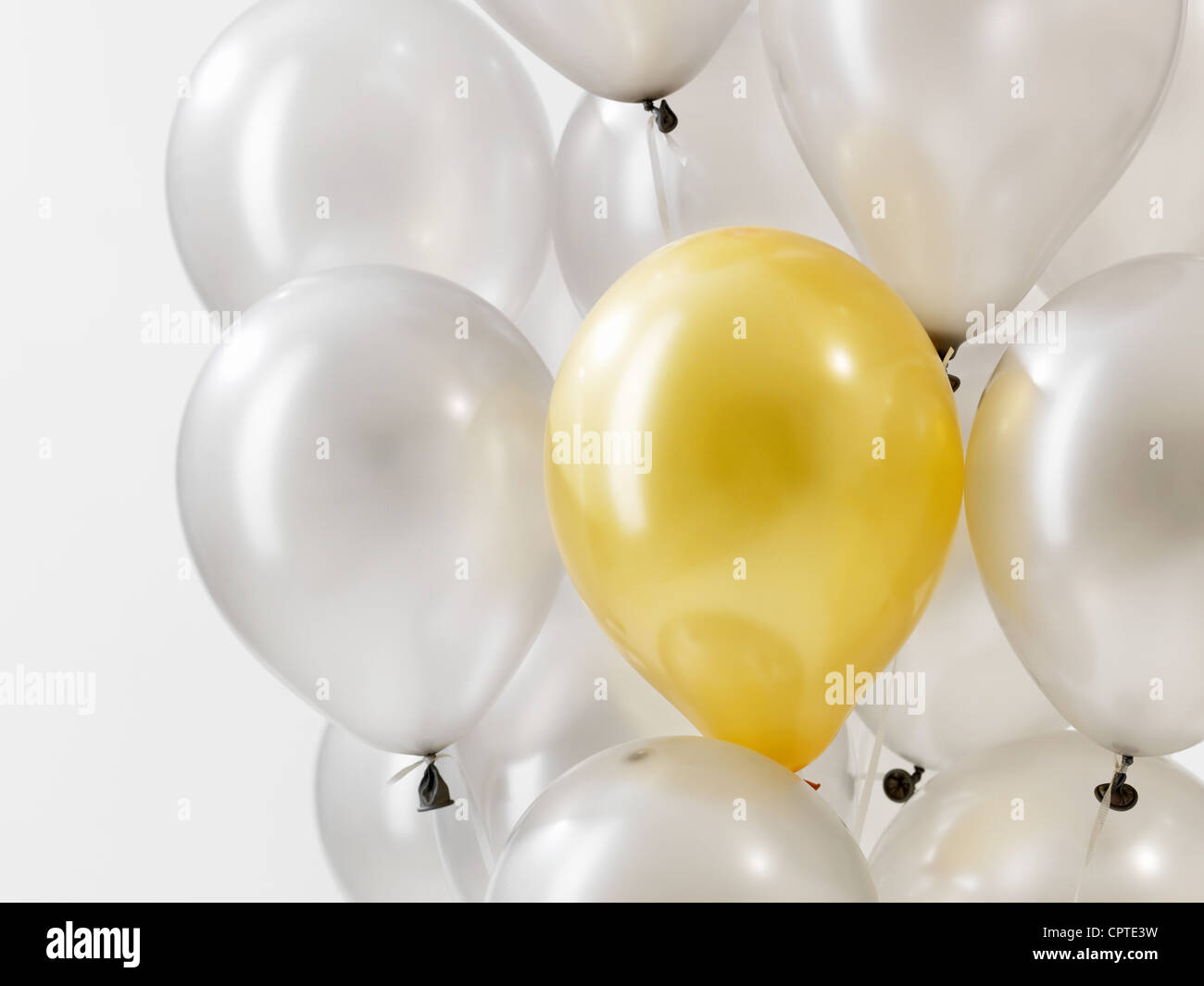 Golden balloon in silver balloons against white background Stock Photo ...