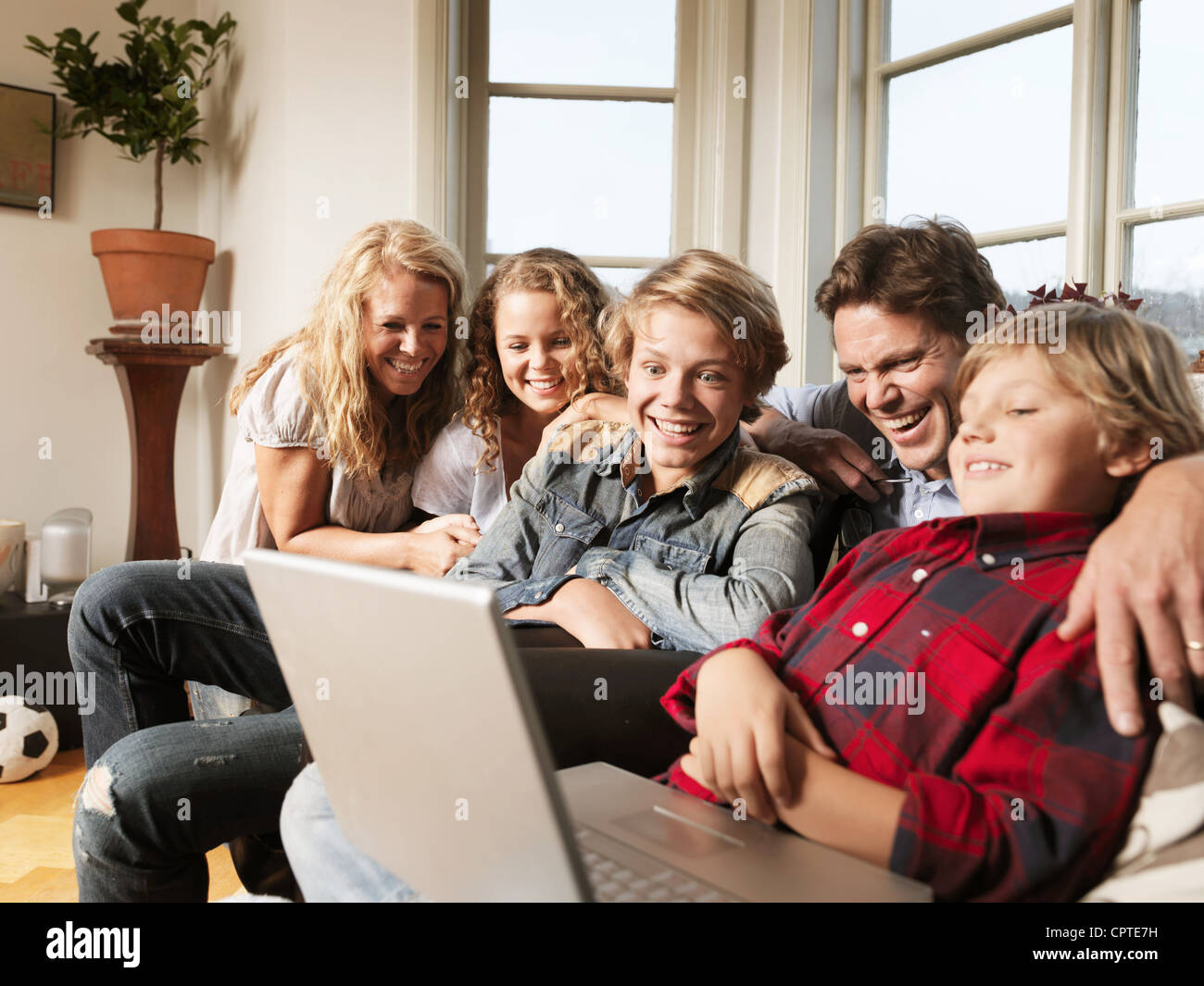 Family watching laptop together on sofa Stock Photo - Alamy