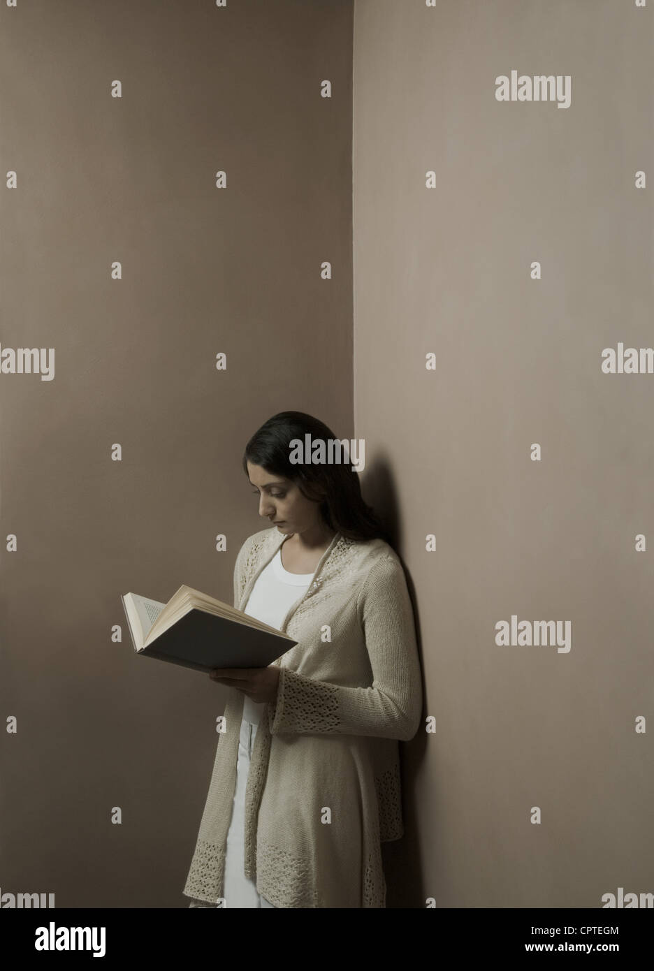 Woman reading book in corner of room Stock Photo - Alamy