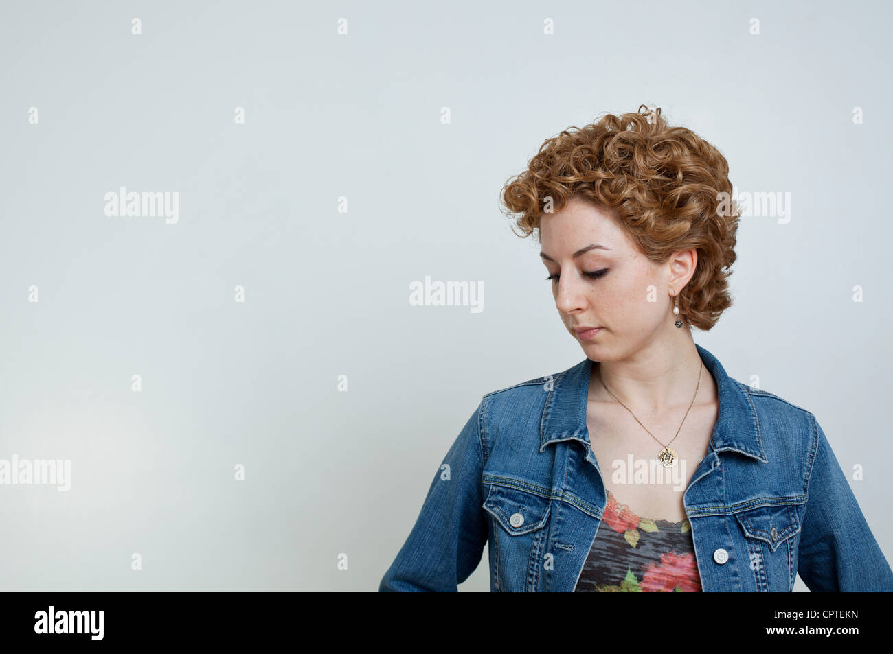Young woman looking down, studio shot Stock Photo - Alamy