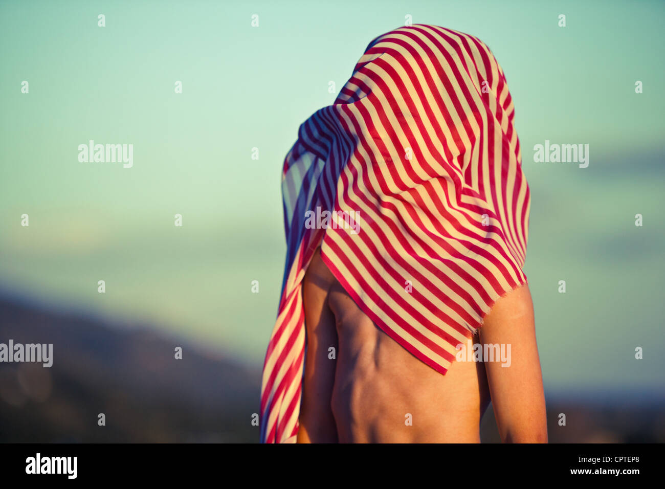 Boy covering head with striped fabric Stock Photo - Alamy
