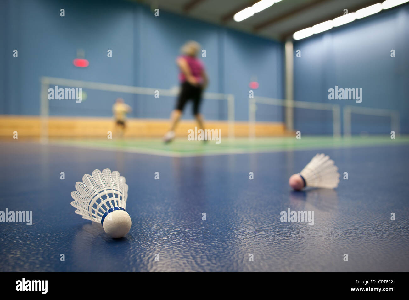 badminton - badminton courts with players competing; shuttlecocks in ...