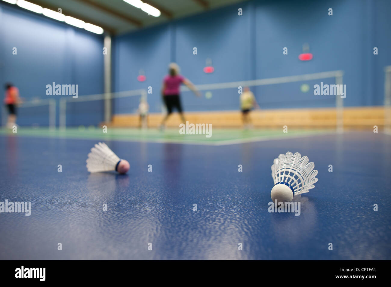 badminton - badminton courts with players competing; shuttlecocks in ...