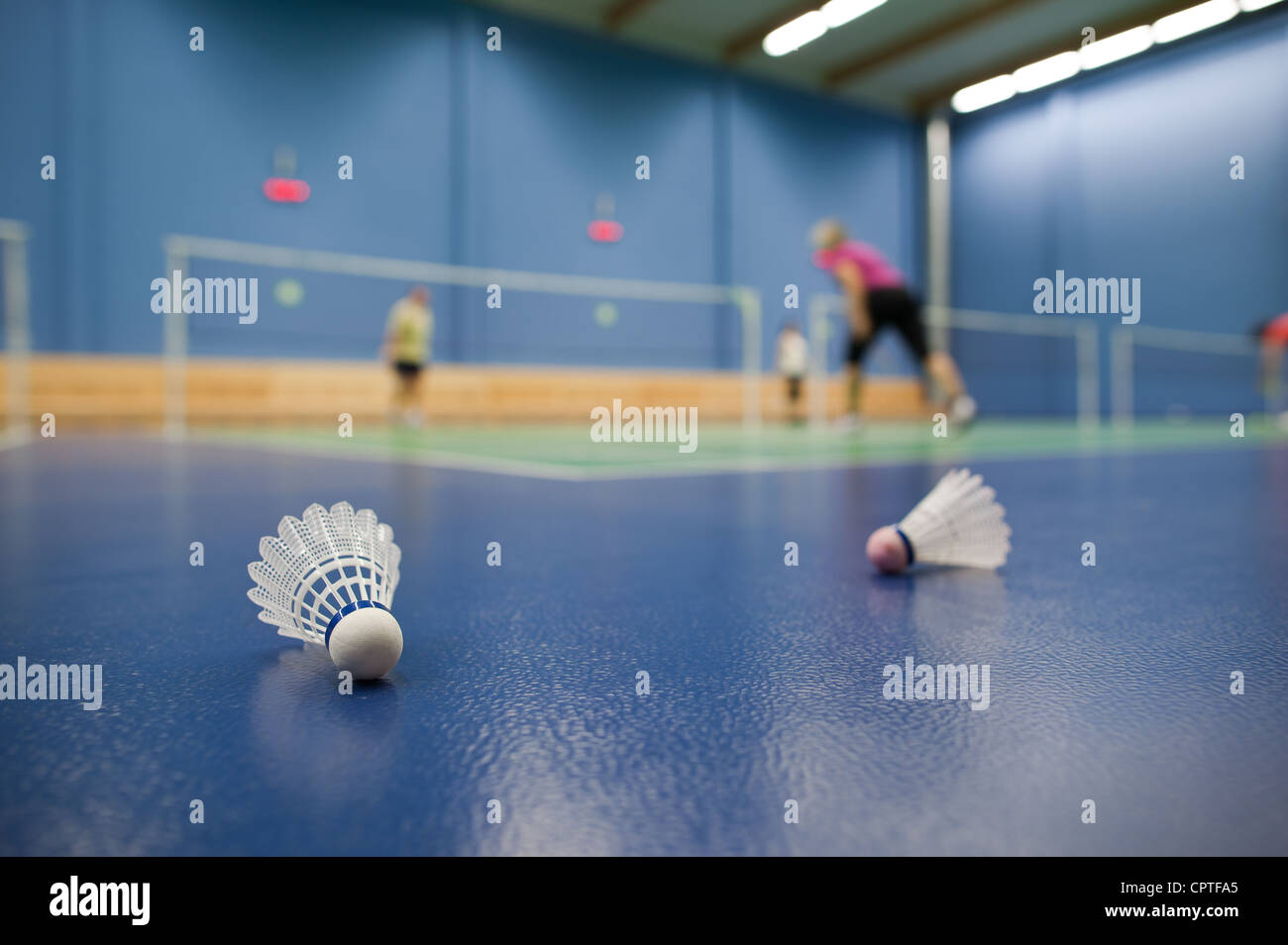badminton - badminton courts with players competing; shuttlecocks in ...