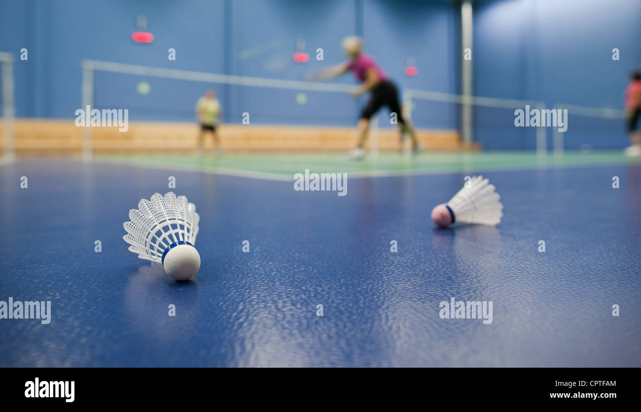 badminton - badminton courts with players competing; shuttlecocks in ...