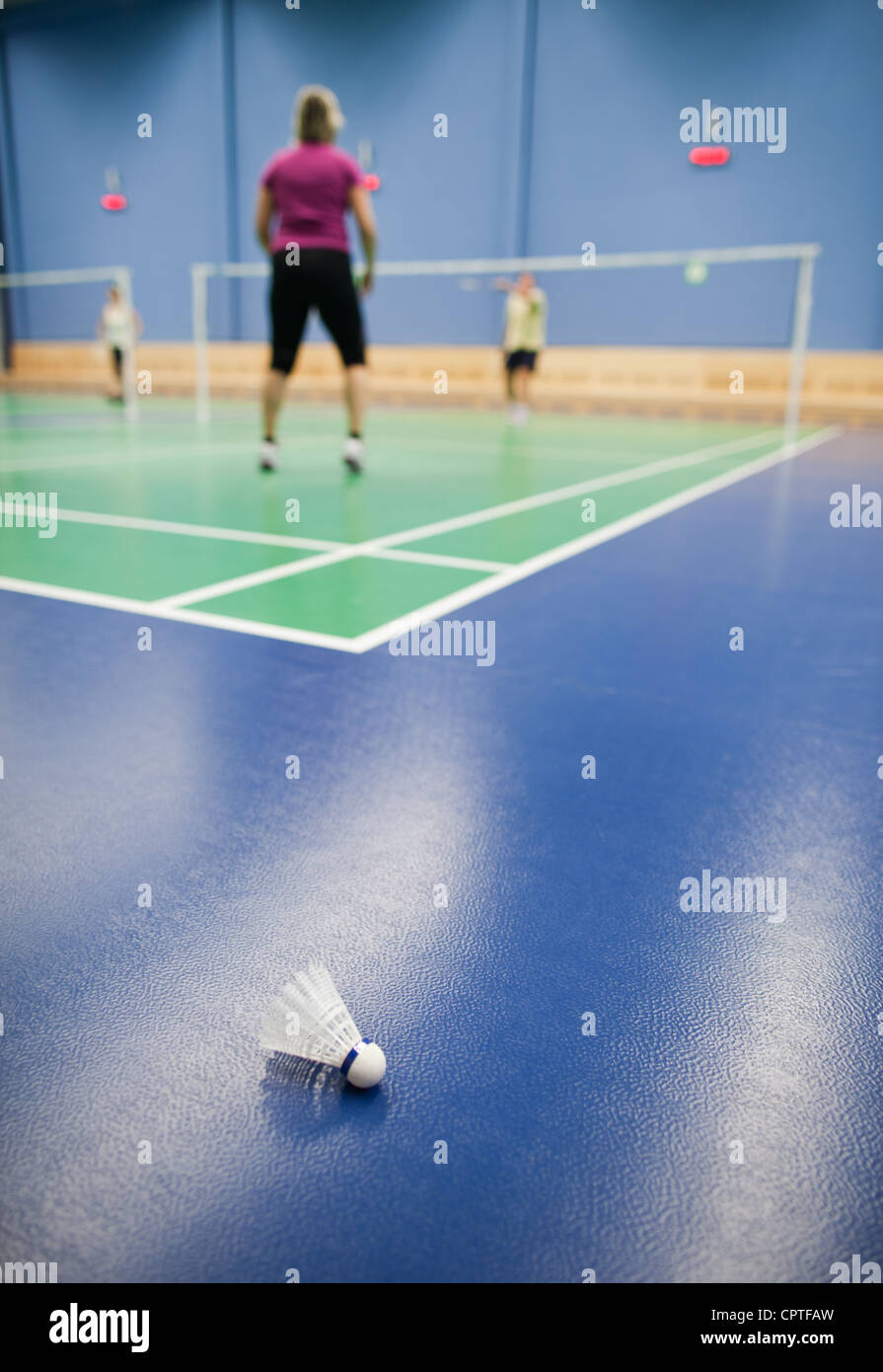 badminton - badminton courts with players competing; shuttlecocks in ...