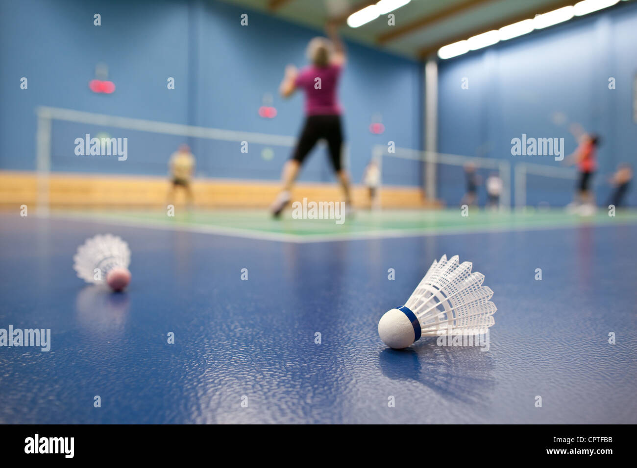 badminton - badminton courts with players competing; shuttlecocks in ...
