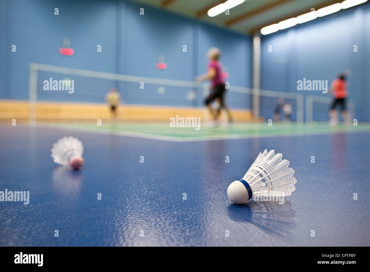 badminton - badminton courts with players competing; shuttlecocks in ...