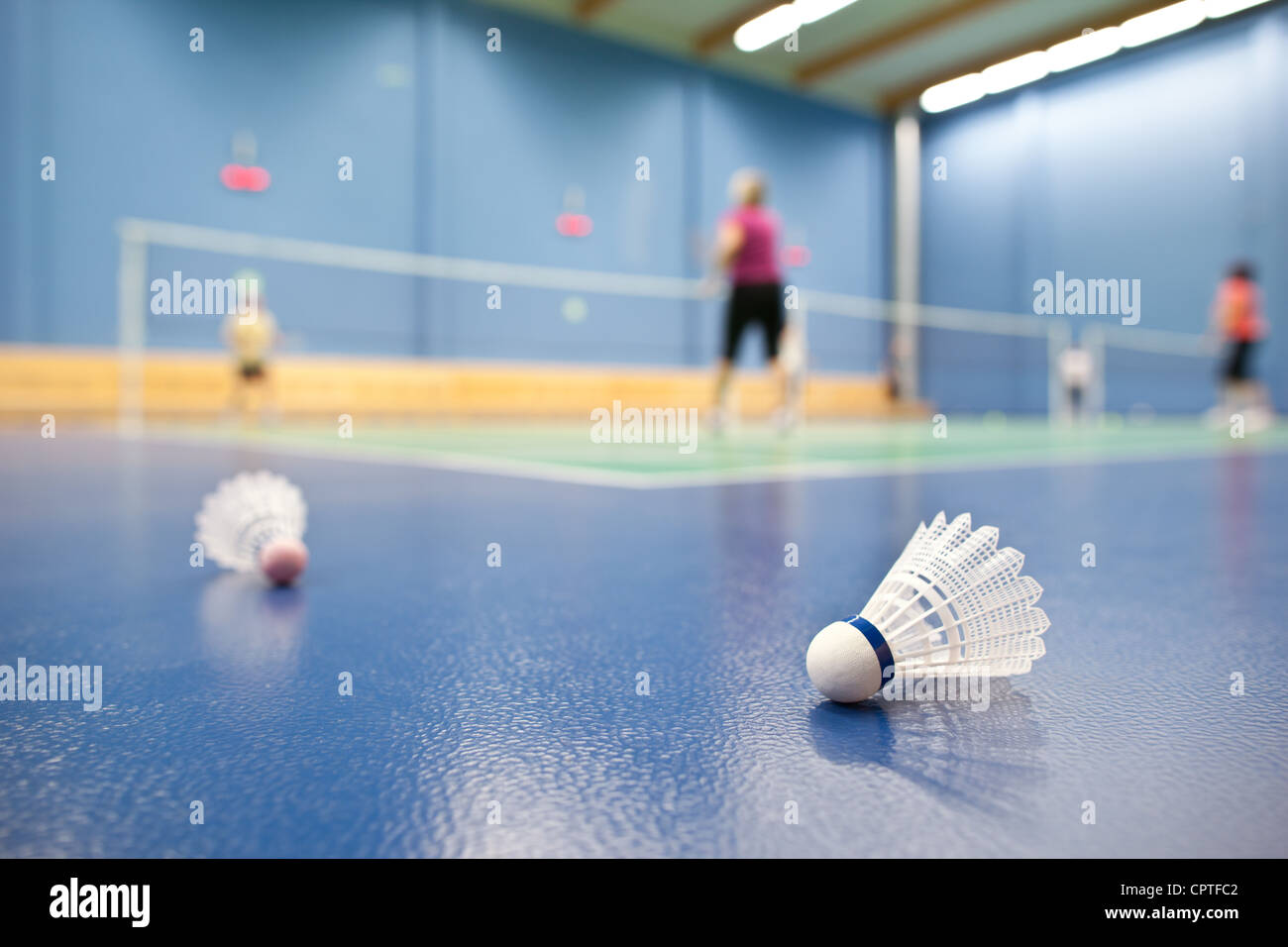 badminton - badminton courts with players competing; shuttlecocks in ...