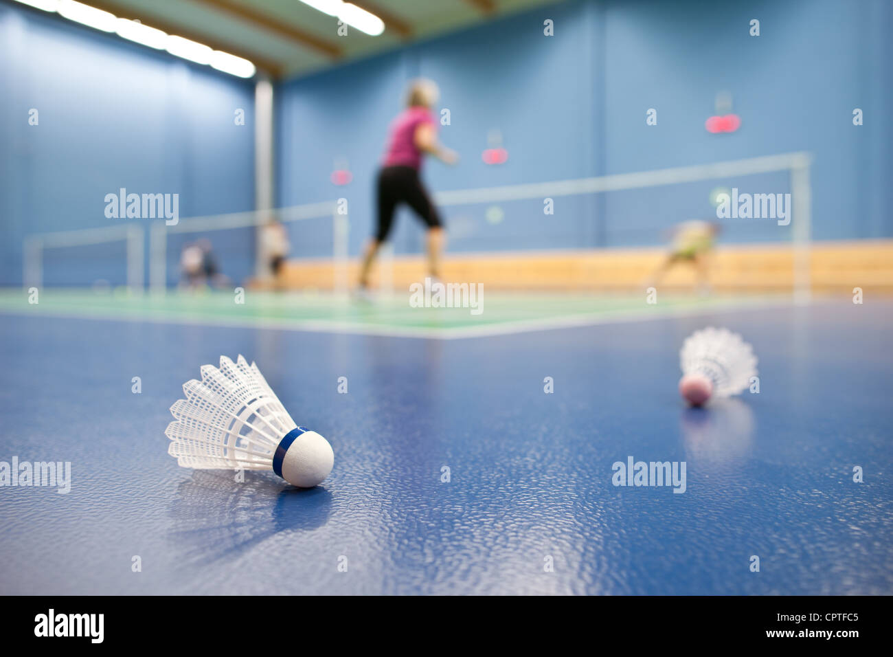 badminton - badminton courts with players competing; shuttlecocks in ...