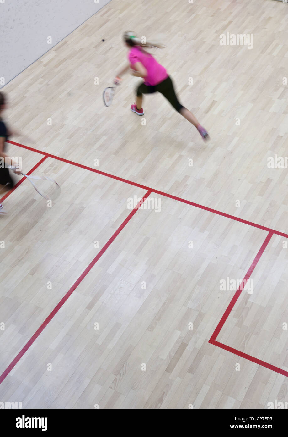 Two female squash players in fast action on a squash court (motion ...