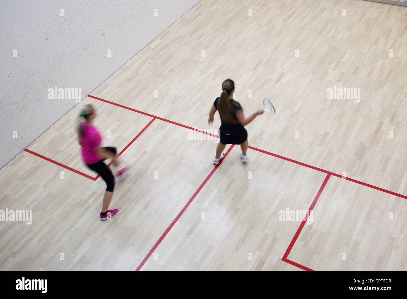 Two female squash players in fast action on a squash court (motion ...