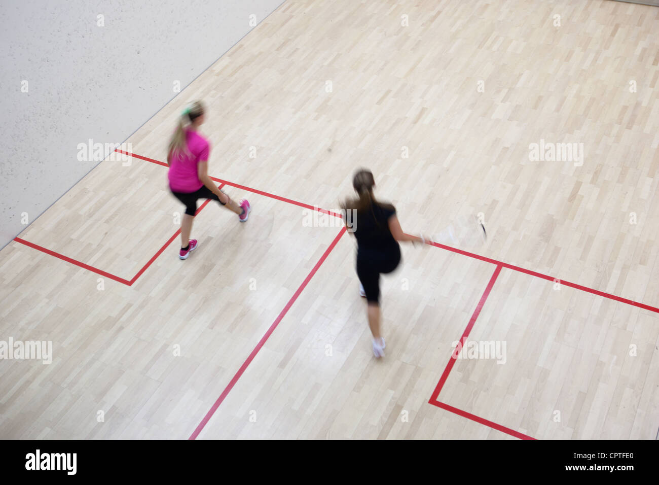 Two female squash players in fast action on a squash court (motion ...