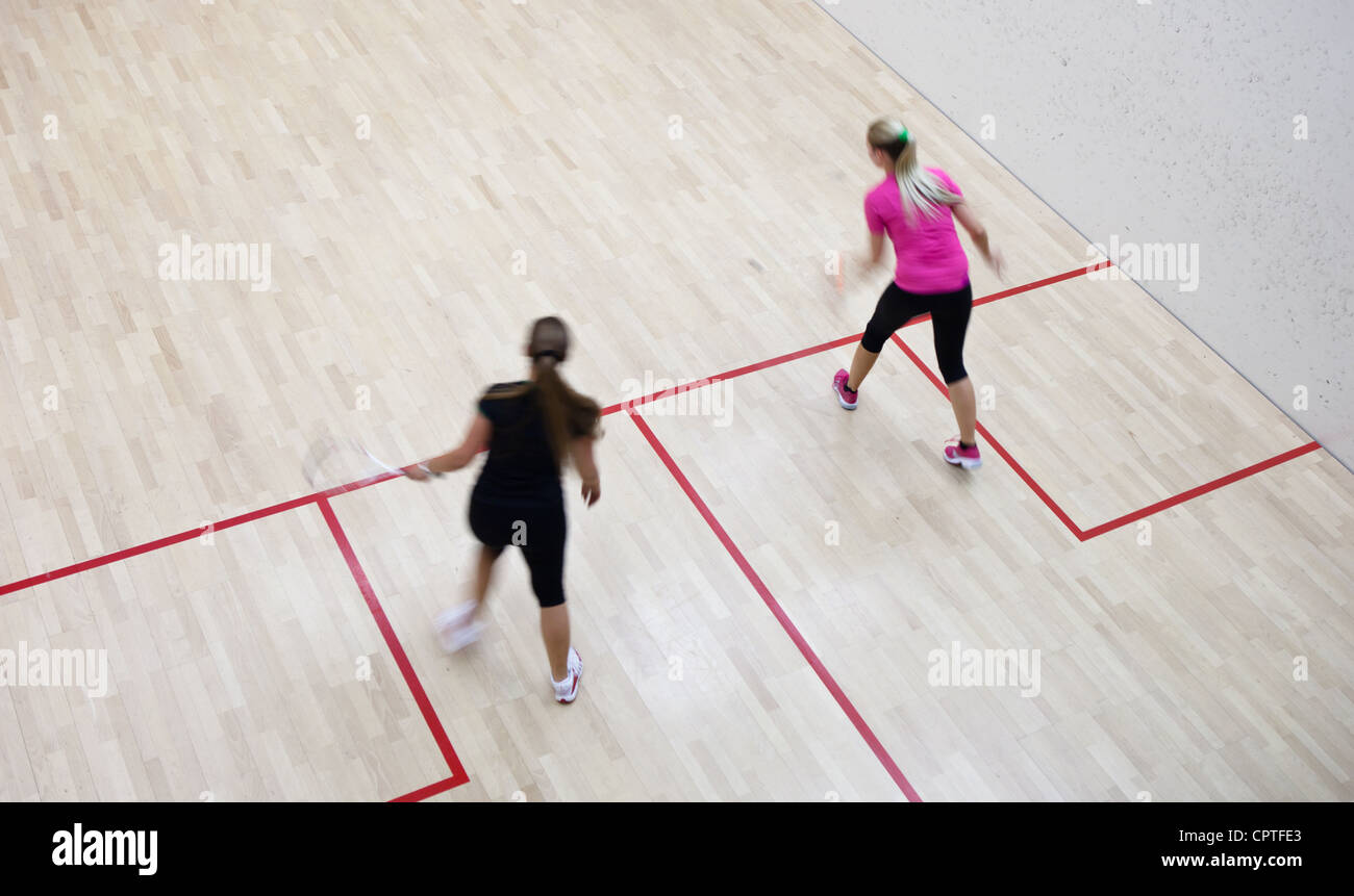 Two female squash players in fast action on a squash court (motion ...