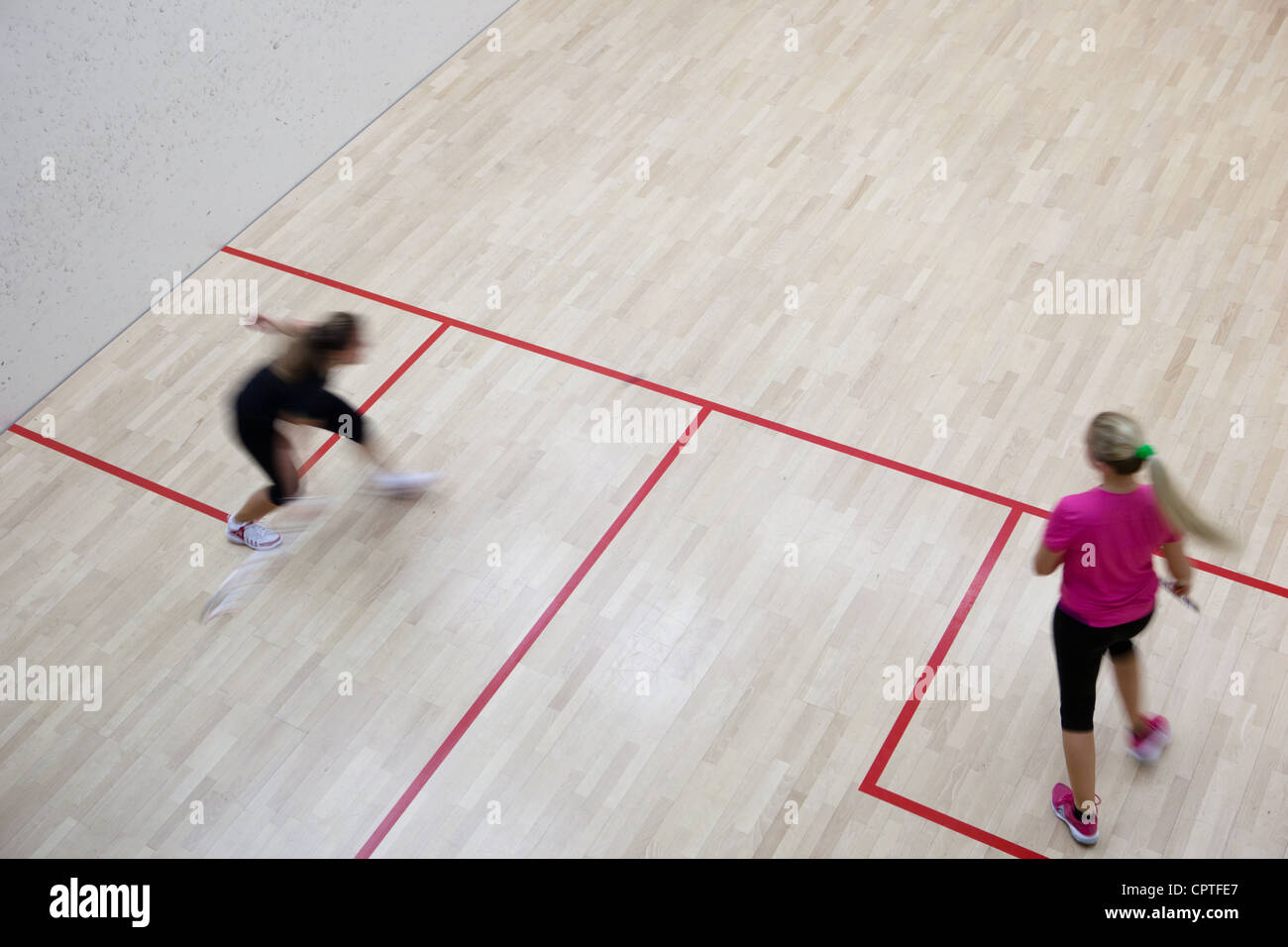 Two female squash players in fast action on a squash court (motion ...