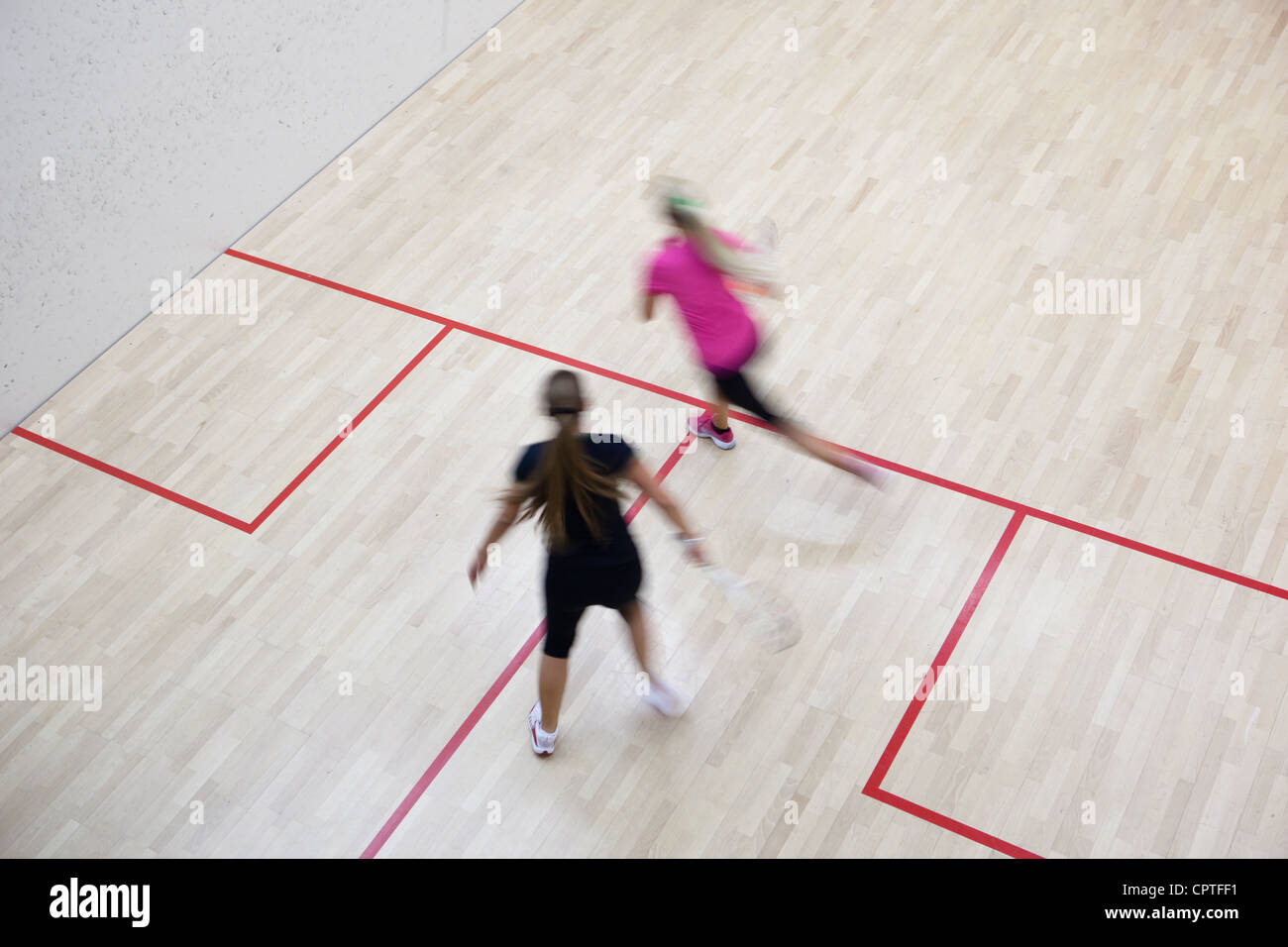 Two female squash players in fast action on a squash court (motion ...