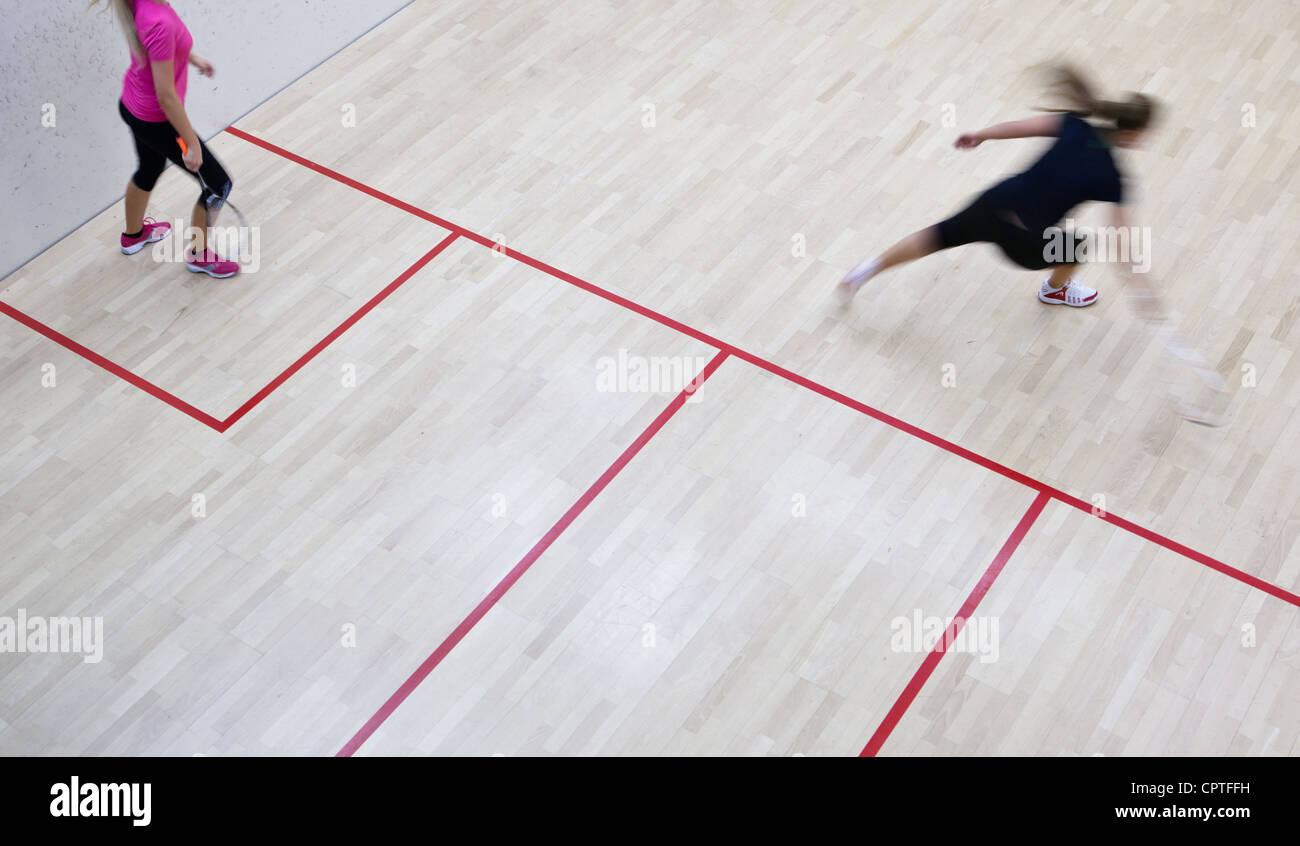 Two female squash players in fast action on a squash court (motion ...