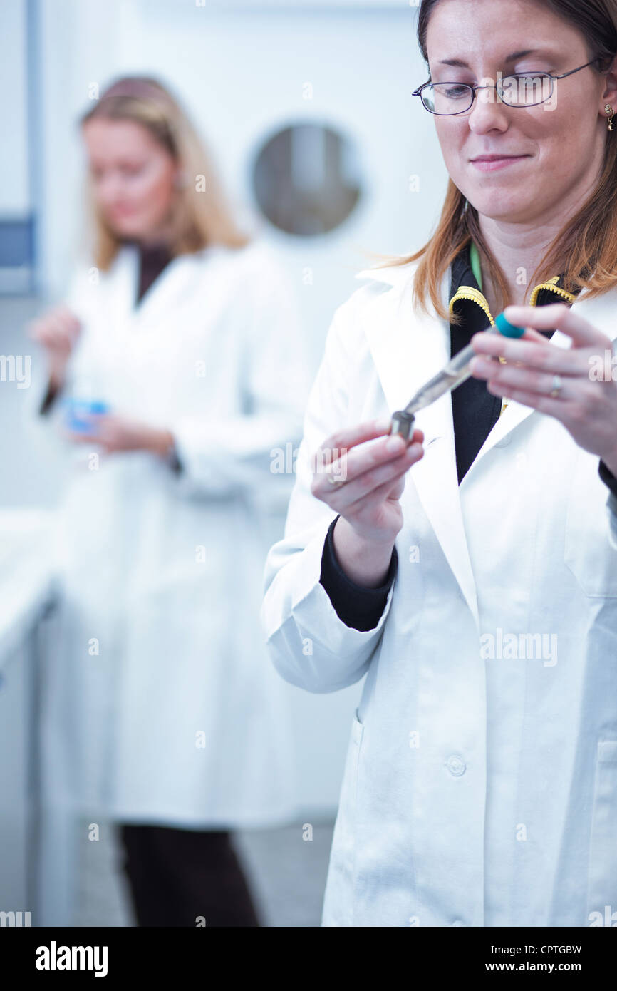 Two female researchers carrying out research in a chemistry ...