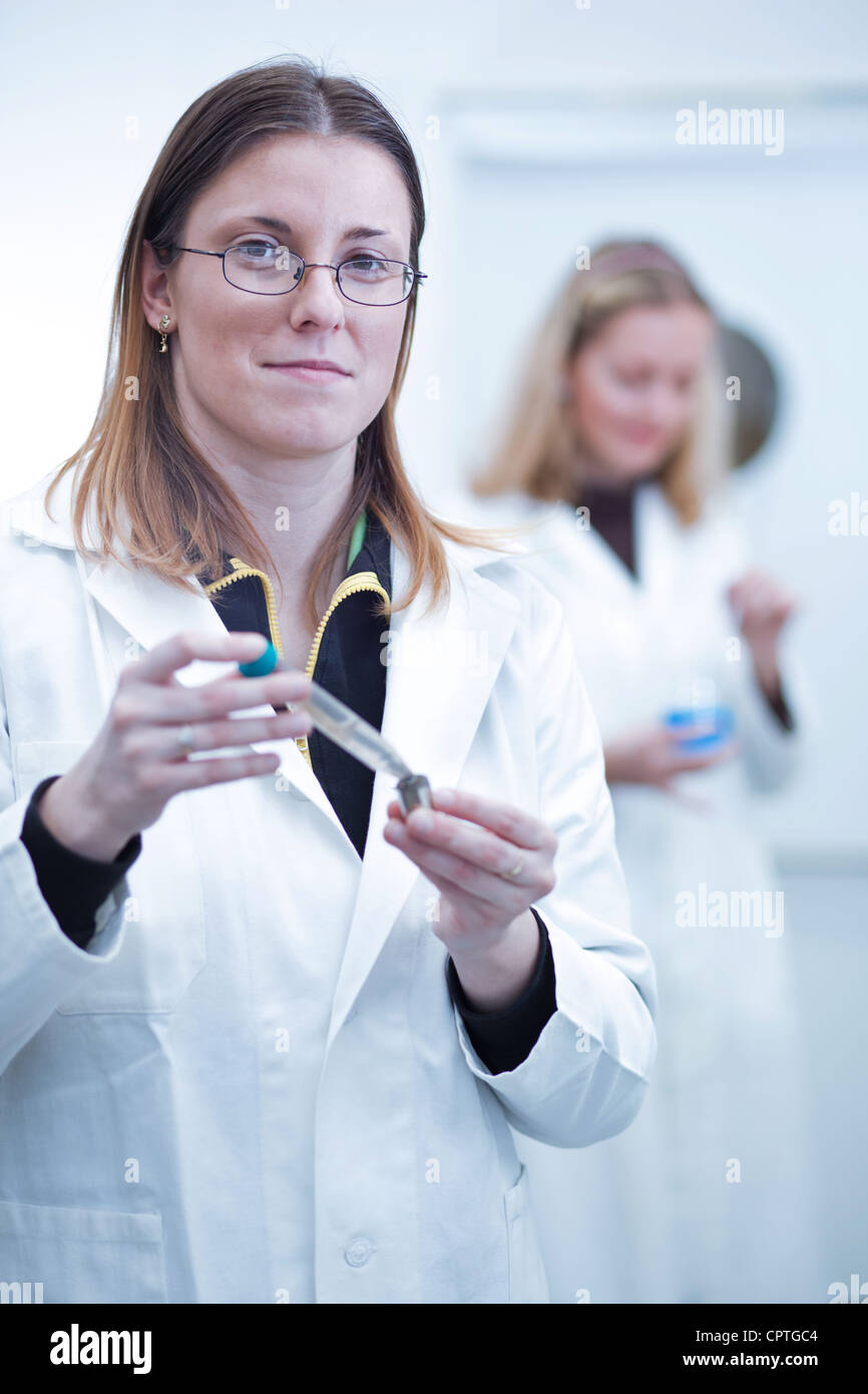 Two female researchers carrying out research in a chemistry ...