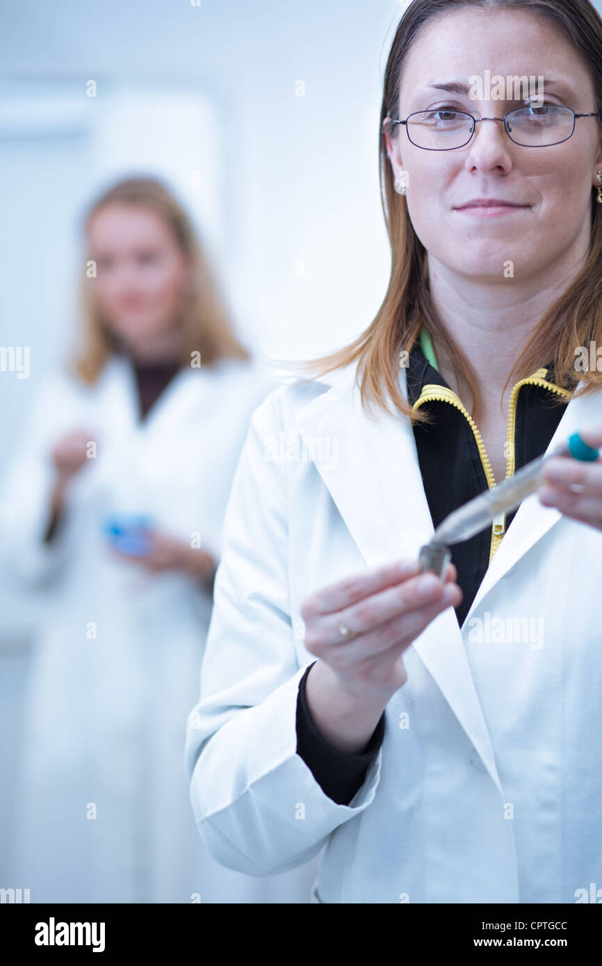 Two female researchers carrying out research in a chemistry ...