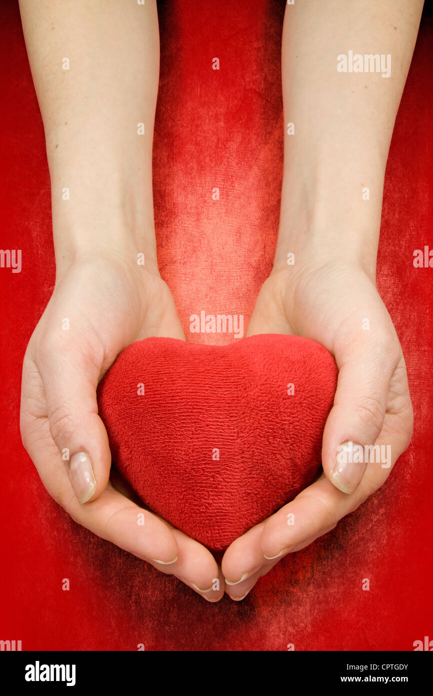 hands with heart on red grunge background Stock Photo - Alamy
