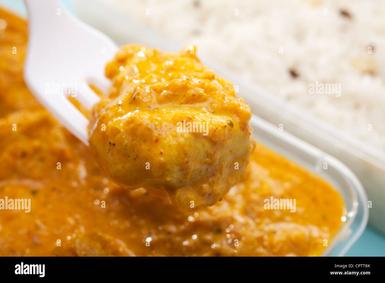 Fork lifting piece of Indian take away meal of chicken bhoona or bhuna ...