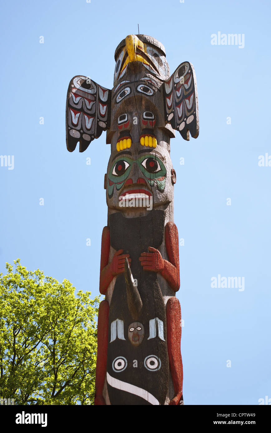 Totem pole on blue sky background and green tree Stock Photo - Alamy