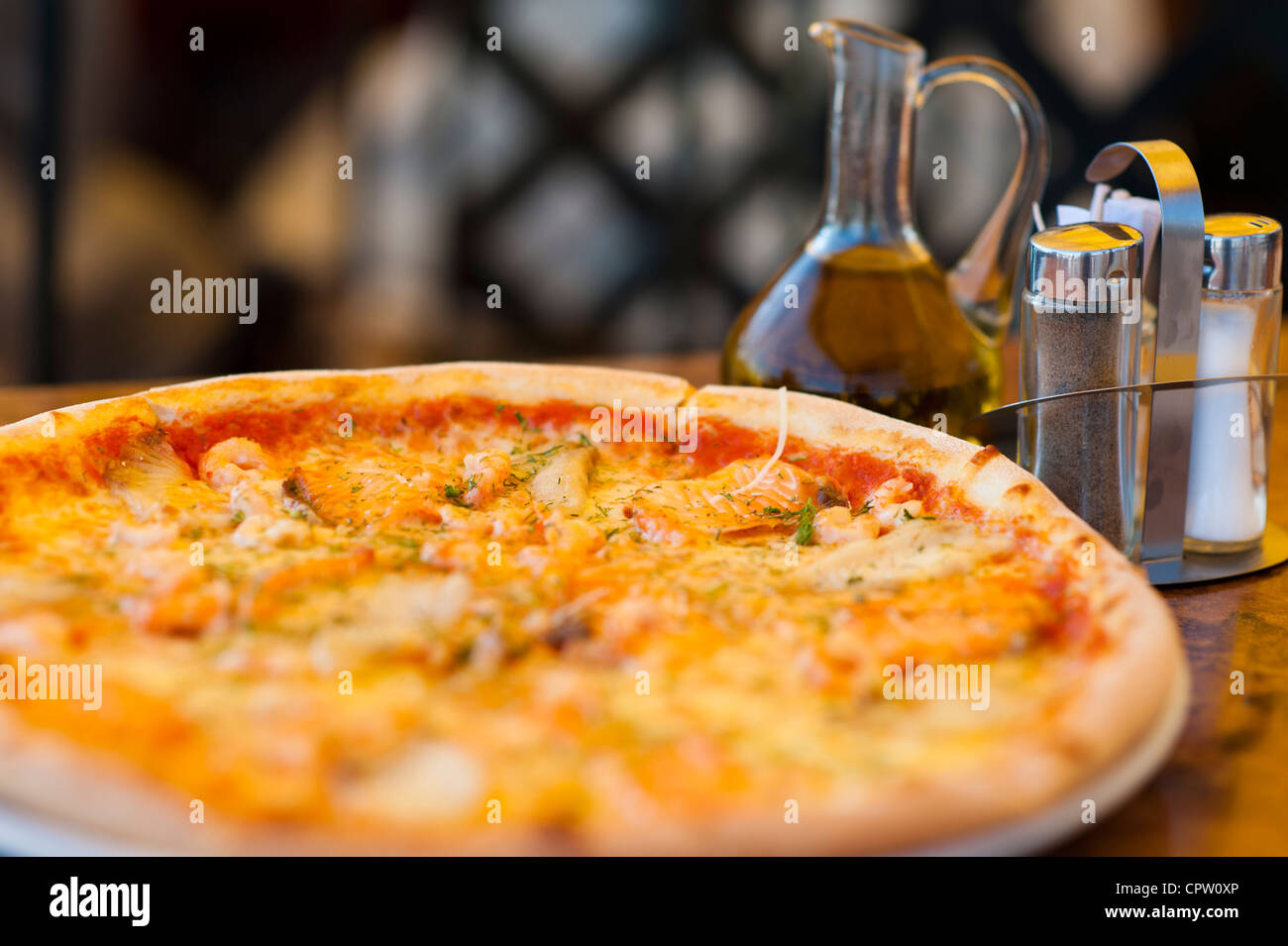 Pizza with red fish and cheese on cafe table Stock Photo - Alamy