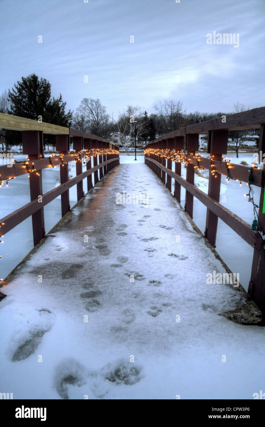 Deer tracks, footprints, and Christmas lights on a bridge in the ...