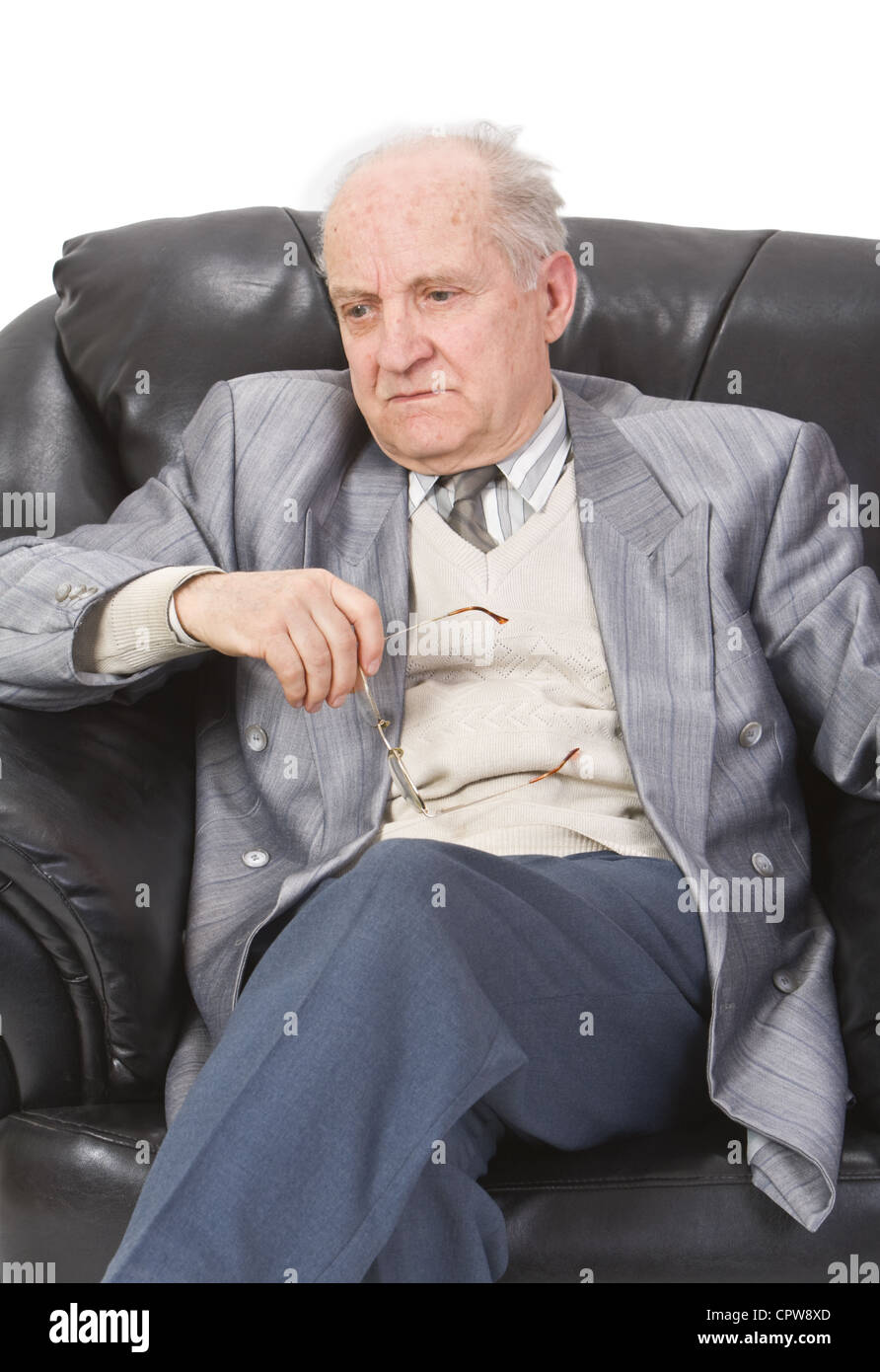 Portrait of a senior man sitting in an armchair and thinking deeply ...