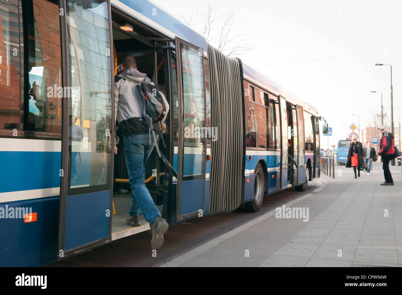 Young man getting into bus at the bus stop in Krakow, Poland Stock ...